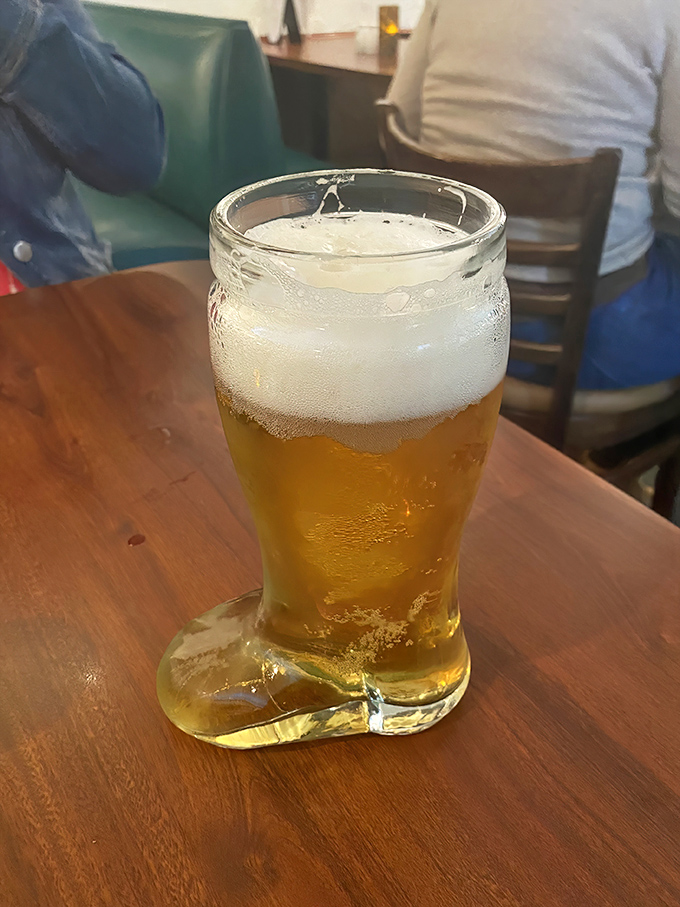 Not just a beer—a cultural experience in glass boot form. The condensation says "I'm cold," but the amber color whispers "I'm delicious."