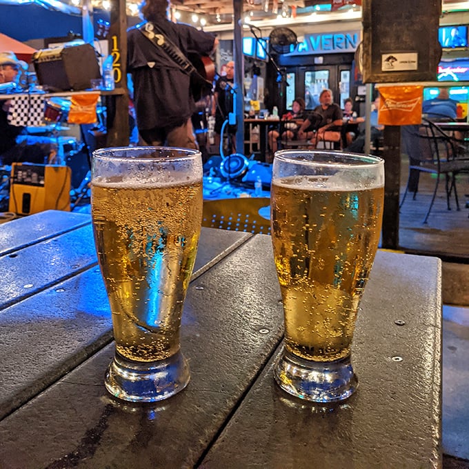 Two perfectly poured beers catching the blue glow of neon signs—a sight as beautiful to tavern-goers as a sunset is to poets.
