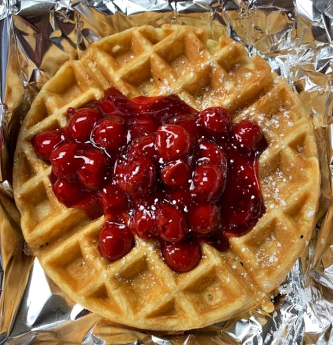 A waffle crowned with cherries so vibrant they look like edible rubies. Breakfast jewelry at its most delicious.