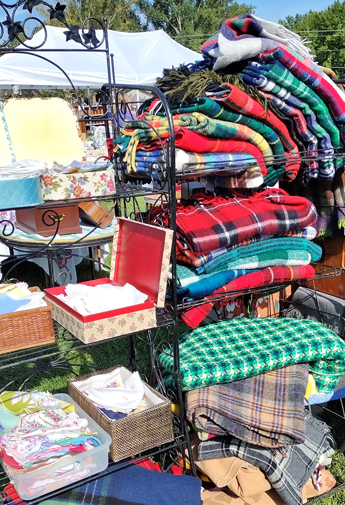 Woolen treasures stacked high—these aren't just blankets but time machines to cabin weekends and fireside evenings of yesteryear.
