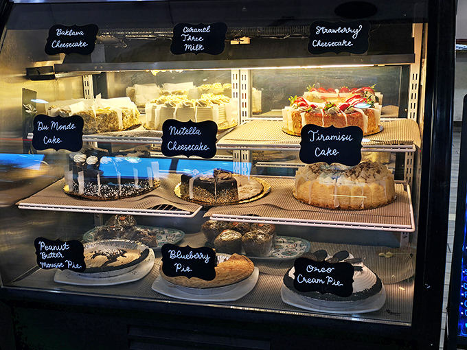 The dessert case – a glass-enclosed museum of temptation where willpower goes to die. That tiramisu is practically winking at you. 