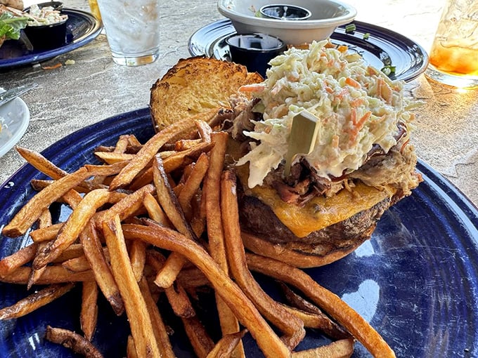 This isn't just a sandwich—it's a towering achievement of culinary engineering with hand-cut fries standing guard alongside.