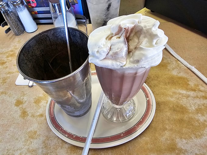 That chocolate shake stands tall with whipped cream confidence, ready to transport you straight back to childhood bliss.