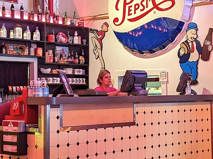 The counter isn't just where transactions happen—it's command central, framed by vintage Pepsi characters who've witnessed thousands of "the usual" orders.