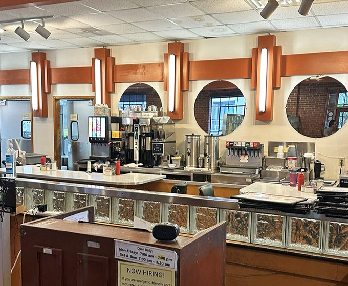 The beating heart of any great diner—a counter setup that's part coffee bar, part command center, with those distinctive round mirrors adding retro charm.