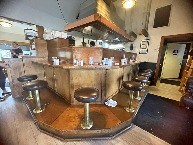 The counter seats—where solo diners become regulars and the best local gossip is exchanged over bottomless cups of coffee.