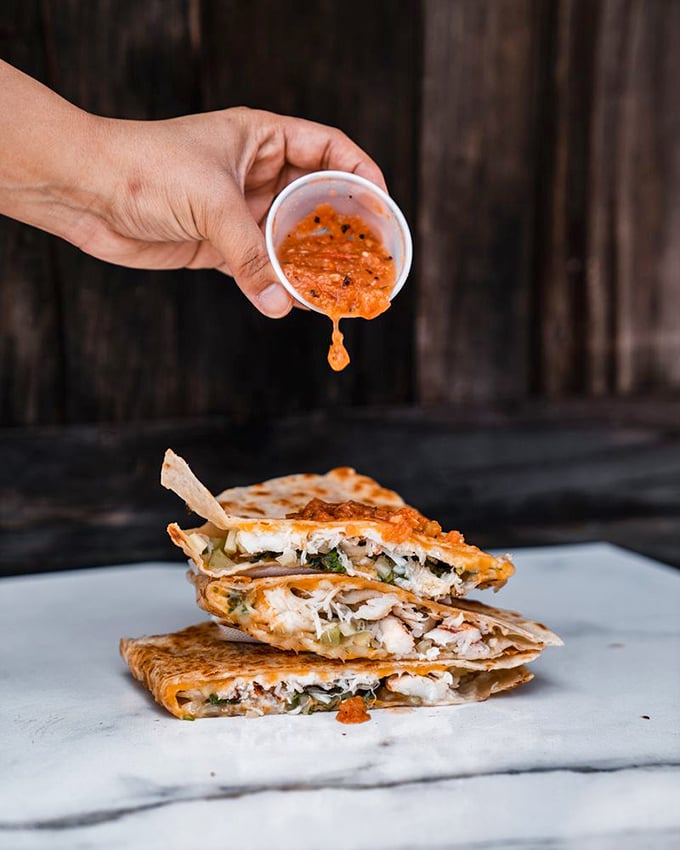 That sauce cascading over seafood quesadilla triangles isn't just condiment—it's liquid excitement, promising flavors that'll make your taste buds stand up and applaud.
