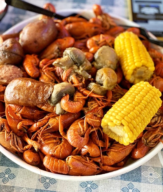 A mountain of bright red crawfish with corn and potatoes—nature's way of saying "use your hands and get messy."