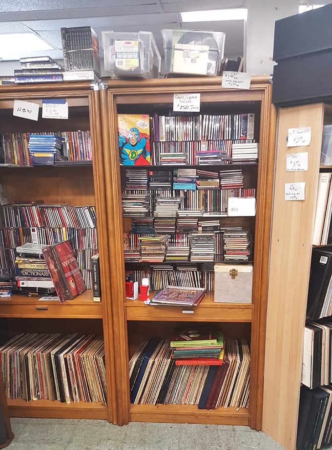 Not just media storage—this is a time capsule of entertainment history. That superhero cutout stands guard over musical and cinematic treasures.