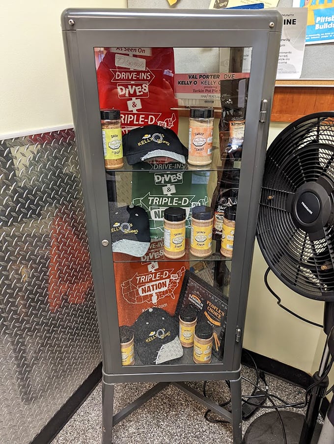 The merch cabinet—proof you're not just eating at Kelly O's, you're joining a movement. Those seasoning bottles are calling your name.