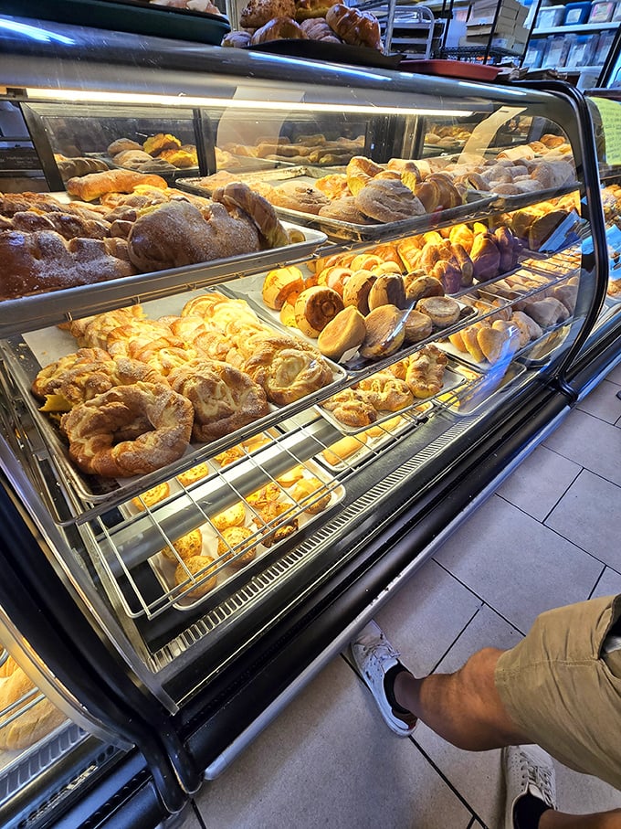 This bakery case isn't just displaying bread—it's showcasing edible art forms that have been perfected over generations and somehow still cost less than your fancy coffee.