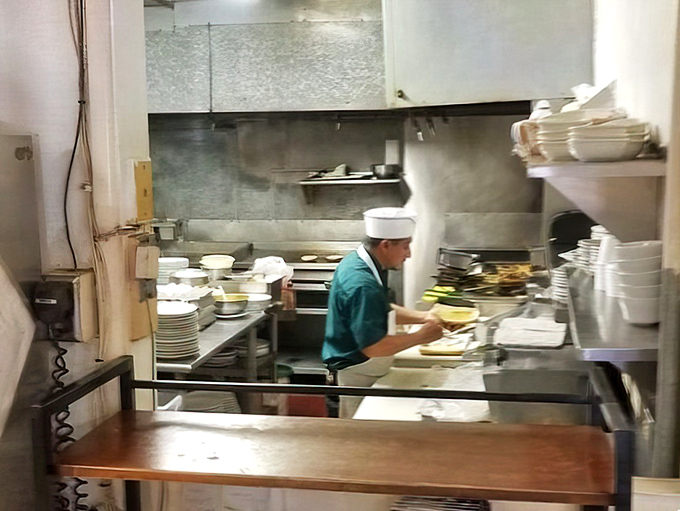 A glimpse into the kitchen reveals the choreography of short-order cooking—where breakfast magic happens without pretense or fanfare.