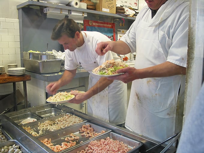 The kitchen dance – skilled hands transforming the ocean's bounty into edible art. No fancy techniques, just respectful preparation of exceptional ingredients.