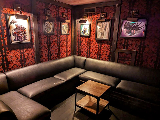Cozy booth seating surrounded by Burton-inspired artwork creates perfect conversation corners for intimate dining. 