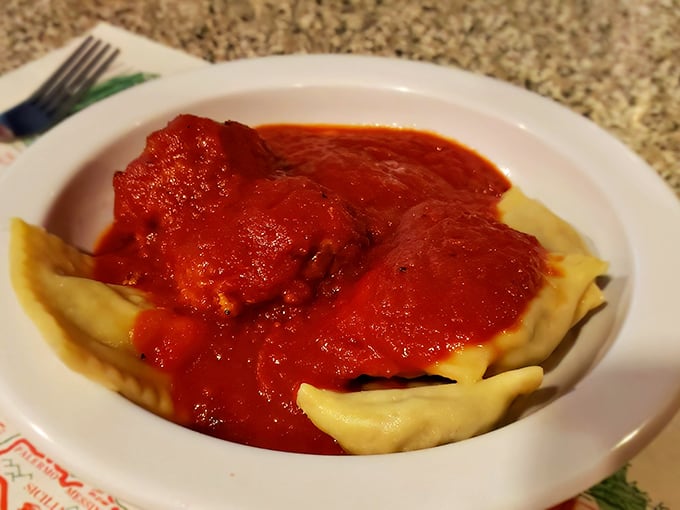 These ravioli aren't just swimming in marinara—they're performing synchronized diving routines in a pool of tomato perfection.