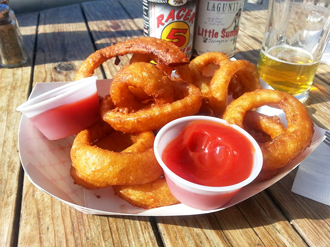 Onion rings that have achieved the perfect crunch-to-tender ratio—like edible gold bracelets paired with a cold local brew.