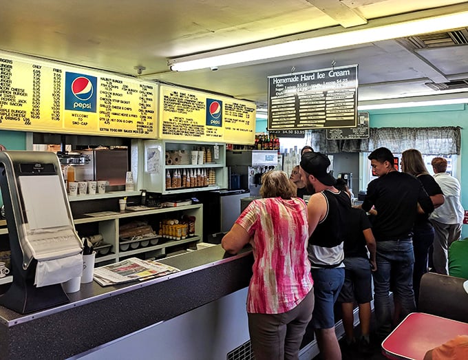 The order counter – where dreams are placed and fulfilled. The menu board above holds no secrets, just straightforward promises of satisfaction.
