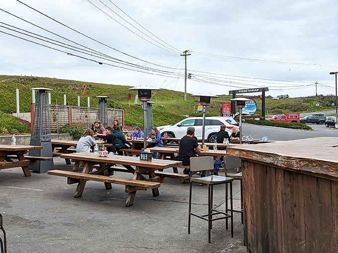 The outdoor seating area where the coastal breeze enhances every bite, and no one minds waiting for a table with views like this.