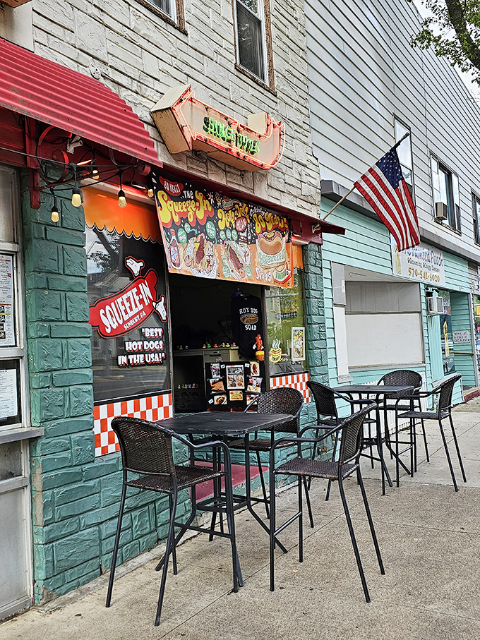 Outdoor seating that says "stay awhile." The American flag flutters overhead as if to declare these hot dogs a national treasure.