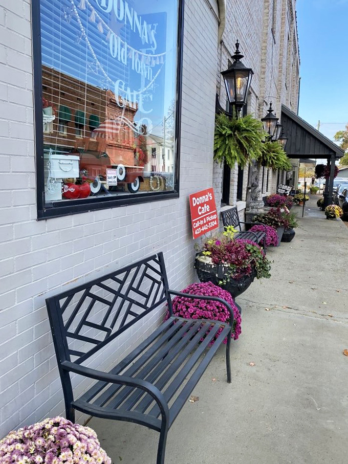 Sidewalk seating framed by vibrant flowers says "slow down and stay awhile." This bench has heard more town gossip than any therapist.