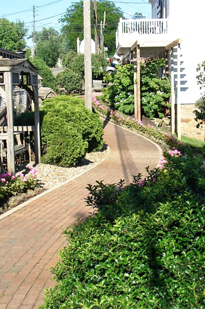 The path less hurried. Brick walkways lined with flowering plants invite visitors to slow down and remember what life was like before rush hour.