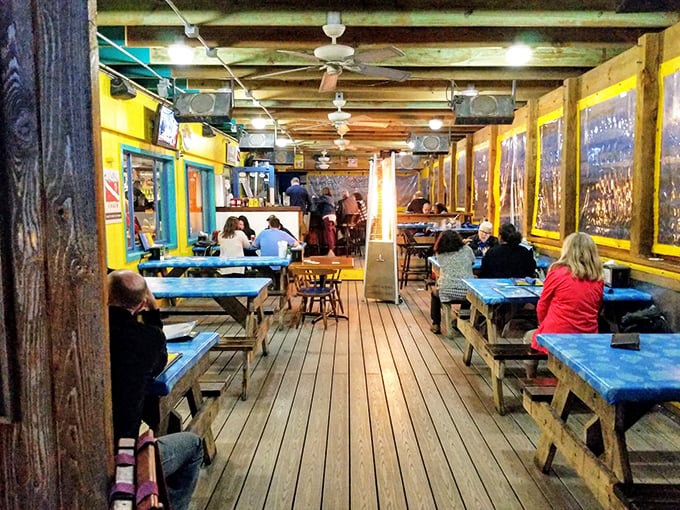 Rustic charm meets waterfront dining. These blue picnic tables and wooden beams create the perfect setting for seafood feasts and sunset-watching sessions.