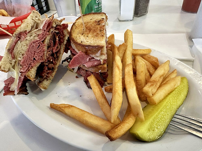 A proper Reuben requires structural integrity and flavor balance – this towering creation delivers both alongside perfectly golden fries.