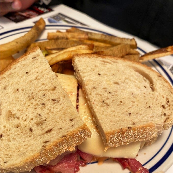 A sandwich that requires both hands and possibly a nap afterward, with fries that aren't just sides—they're co-stars deserving their own billing.