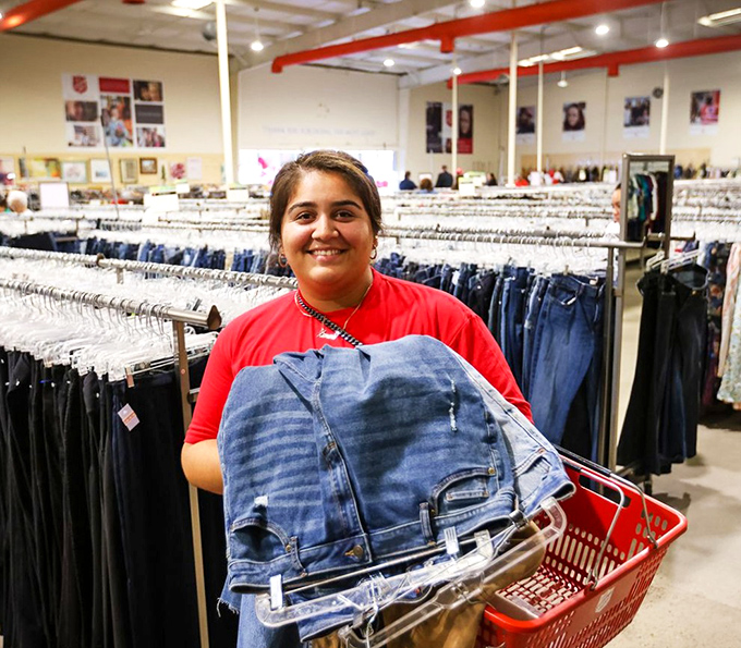 Success! A shopper's smile says it all as she discovers the perfect pair of jeans among thousands—the universal thrift store victory pose.