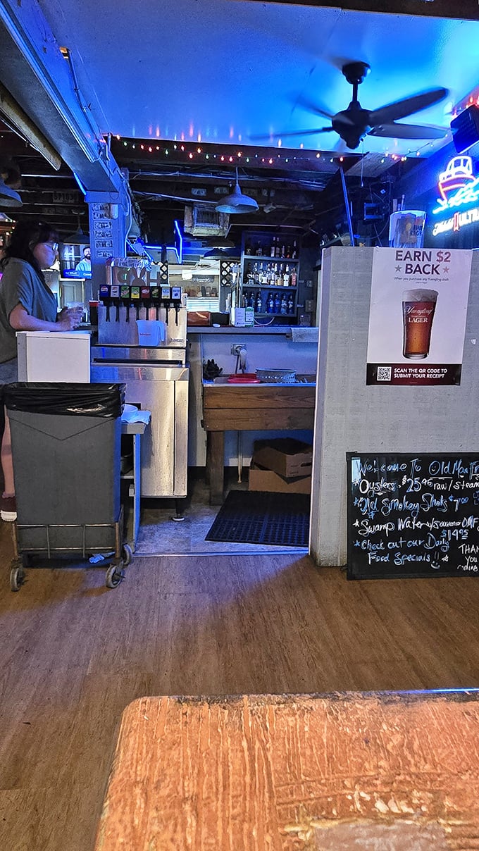 The blue glow of the bar area isn't just mood lighting—it's the backdrop for liquid refreshment that flows as steadily as the conversations around it.