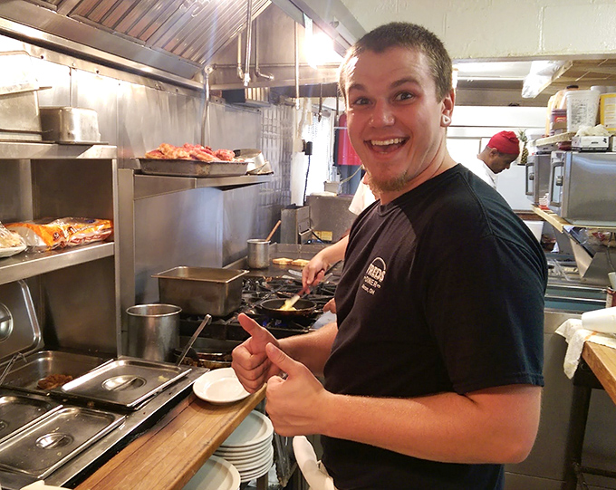 Where the magic happens—a glimpse into the kitchen where smiles are as genuine as the food. That thumbs-up says everything you need to know.