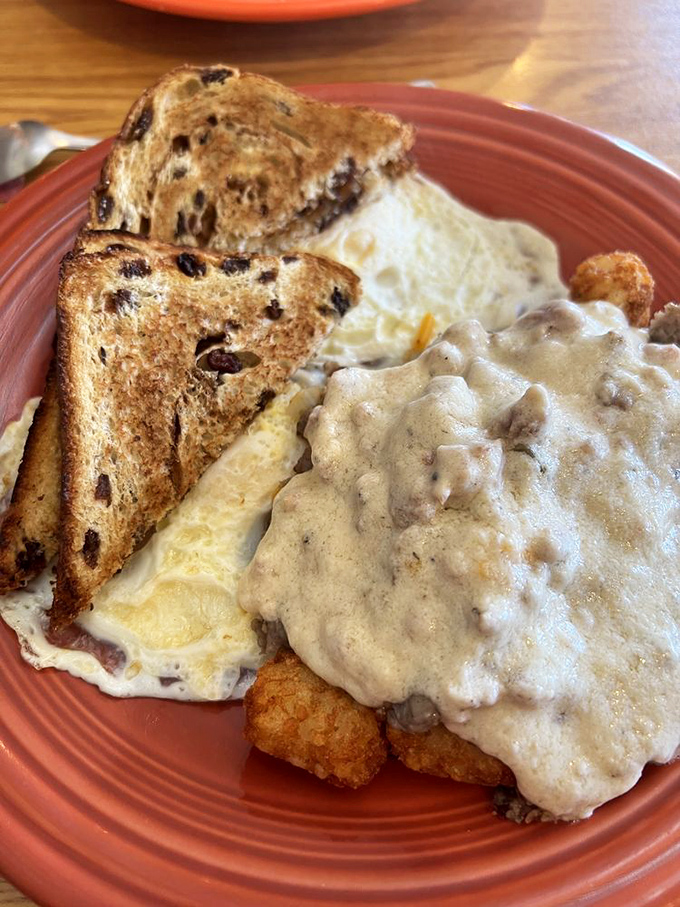 Raisin toast alongside tater tots swimming in gravy—a breakfast that understands sometimes you need both sweet and savory to face the day. 