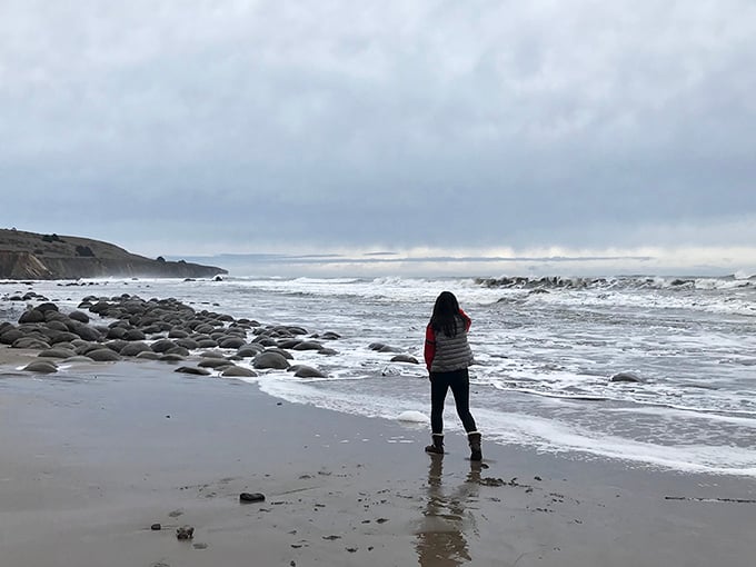 Solitude with a view. One visitor contemplates the vastness of the Pacific while bowling ball rocks play hide-and-seek with the waves.