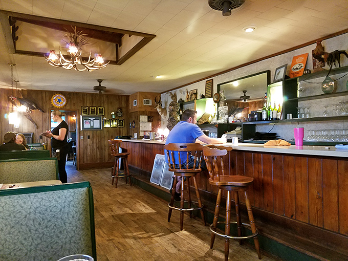 Warm lighting, wood-paneled walls, and an antler chandelier create the perfect atmosphere for savoring slow-cooked specialties and unhurried conversation.