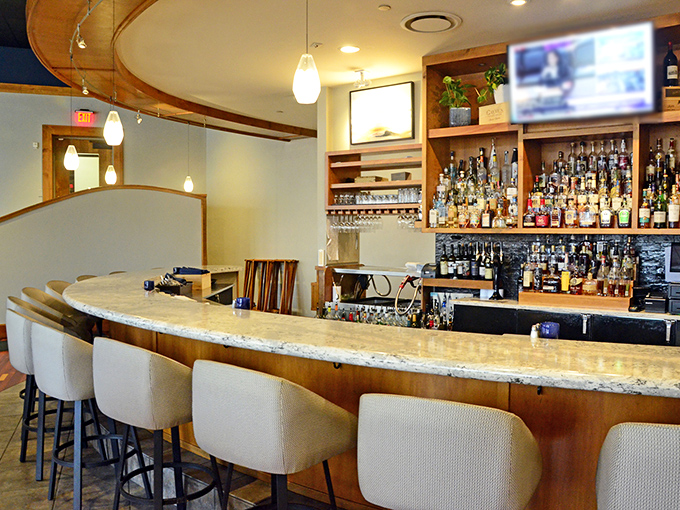 The curved bar invites you to settle in for a pre-dinner cocktail or post-meal nightcap—either way, you're not rushing home.