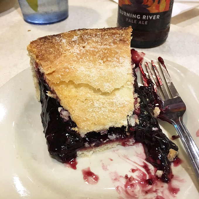 This slice of black raspberry pie isn't just dessert—it's a purple-hued reminder that some pleasures in life are worth every single calorie.