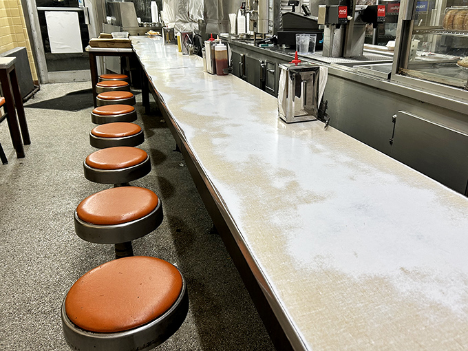 The counter seating at Lafayette isn't about comfort—it's about community. Shoulder-to-shoulder with strangers who become temporary friends over shared coney love.