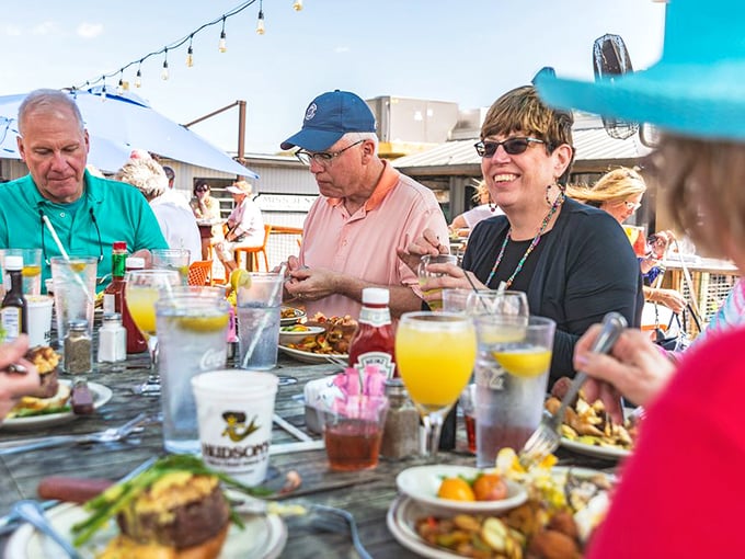 Outdoor dining under Carolina blue umbrellas—where conversations flow as freely as the sweet tea and ocean breeze.
