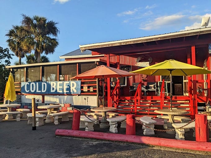 The "COLD BEER" sign isn't just information – it's a siren call to road-weary travelers promising respite under colorful umbrellas and Florida's endless sky.