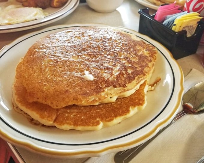 Pancakes stacked higher than your weekend expectations, golden-brown and ready for their maple syrup waterfall moment.
