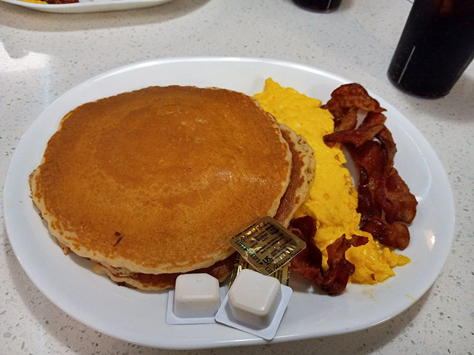 Pancakes so perfectly golden they belong on the Olympic podium, with scrambled eggs and bacon as their proud teammates.