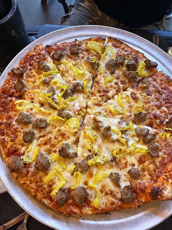 A pizza that doesn't need to show off with trendy toppings—just perfectly balanced cheese, sauce, and those little islands of sausage that make every bite an adventure.