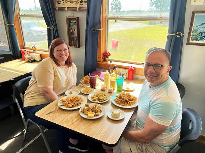 Happy diners surrounded by plates of fried perfection—the universal expression of seafood satisfaction in its natural habitat.