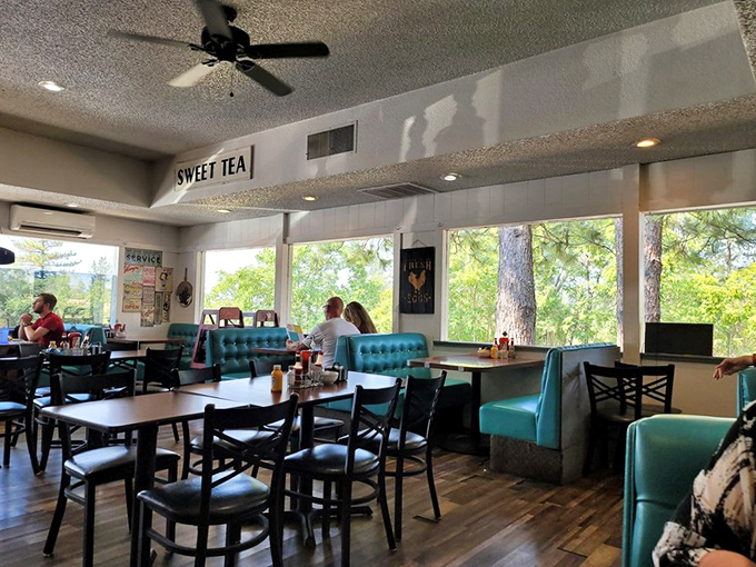 Teal booths frame windows that showcase towering pines outside – nature's perfect backdrop for contemplating whether to order seconds.