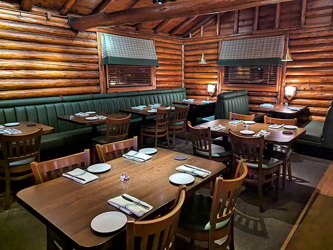 Green booths nestle against log walls creating dining nooks so cozy you might forget you're in a restaurant and not a luxury mountain retreat.