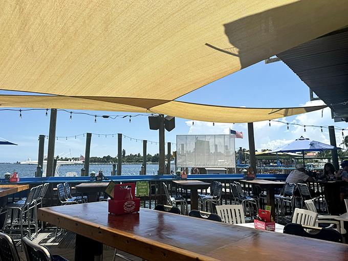 Shade sails and open skies create the perfect dining atmosphere. Even empty tables look inviting when they come with a water view like this.
