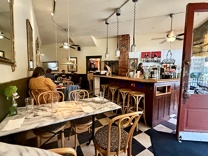 The dining room balances Parisian charm with Midwestern comfort—vintage mirrors reflect the warm conversations happening at marble-topped tables.