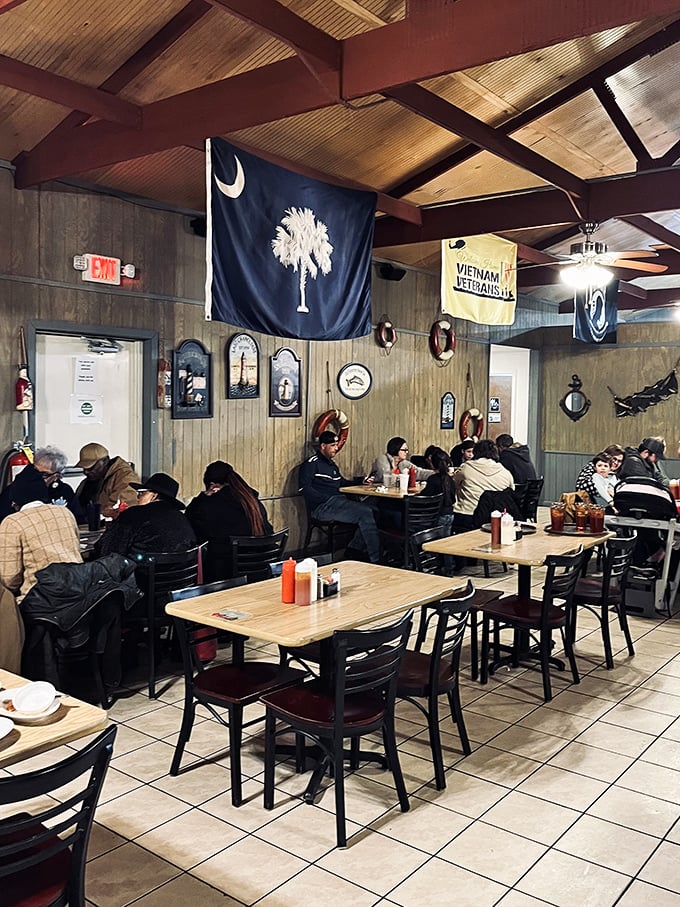 The dining room buzzes with satisfied customers under South Carolina's palmetto flag—a community gathering spot where seafood brings everyone together.