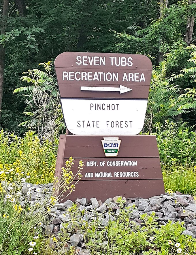The sign that promises adventure—where "Seven Tubs" sounds more like a laundromat but delivers a geological masterpiece instead.
