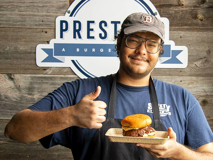 That thumbs-up isn't just for show—it's the universal symbol for "I'm about to hand you something that will change your definition of a perfect burger."